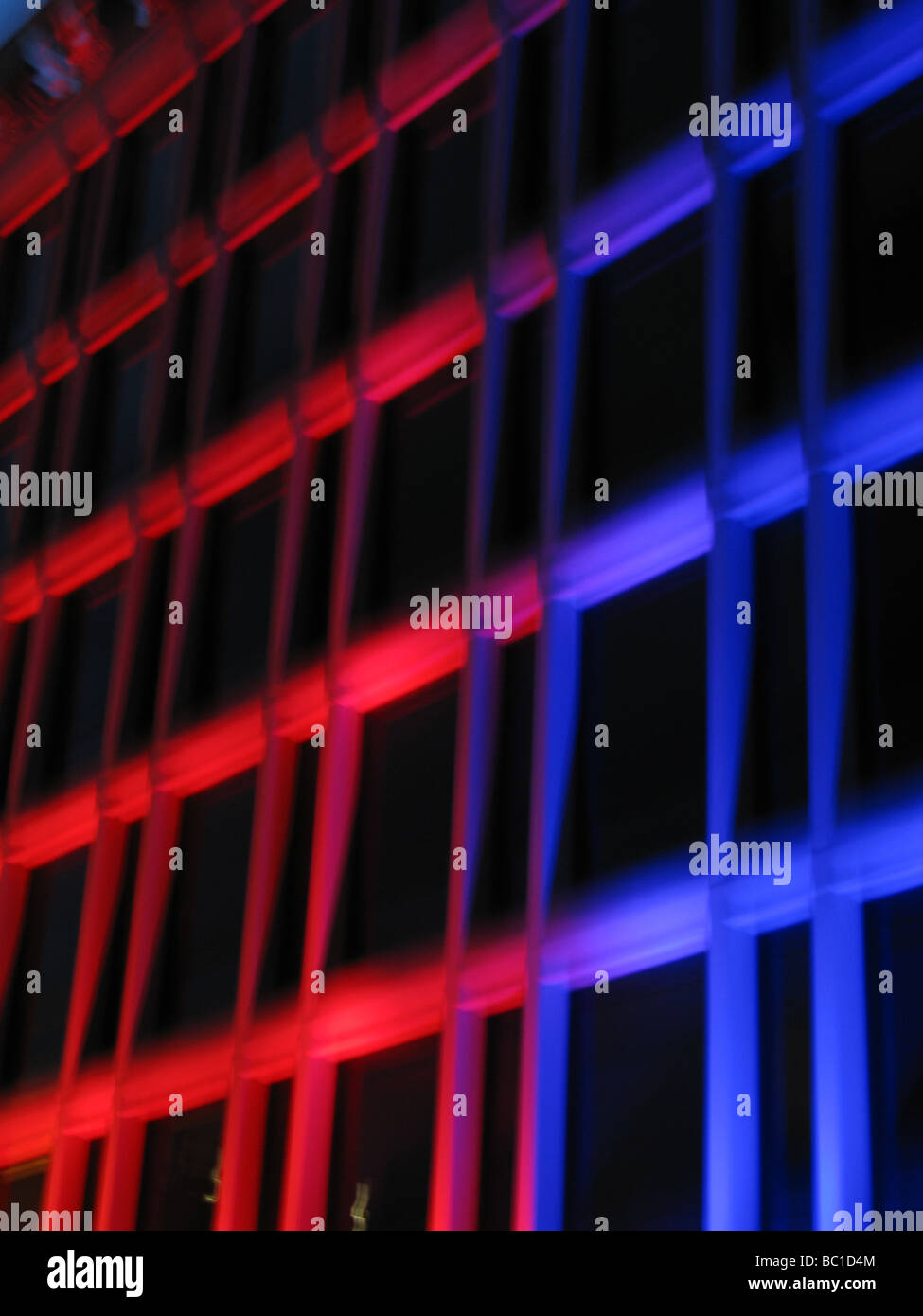 modern office block front illuminated with colourful lights at night ...