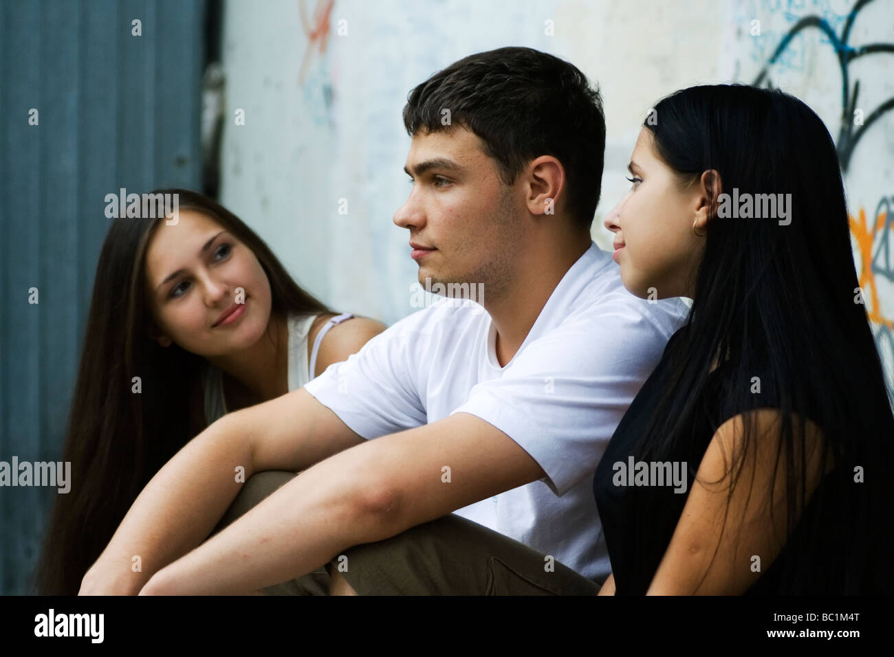 Two girls try to calm their friend Stock Photo - Alamy
