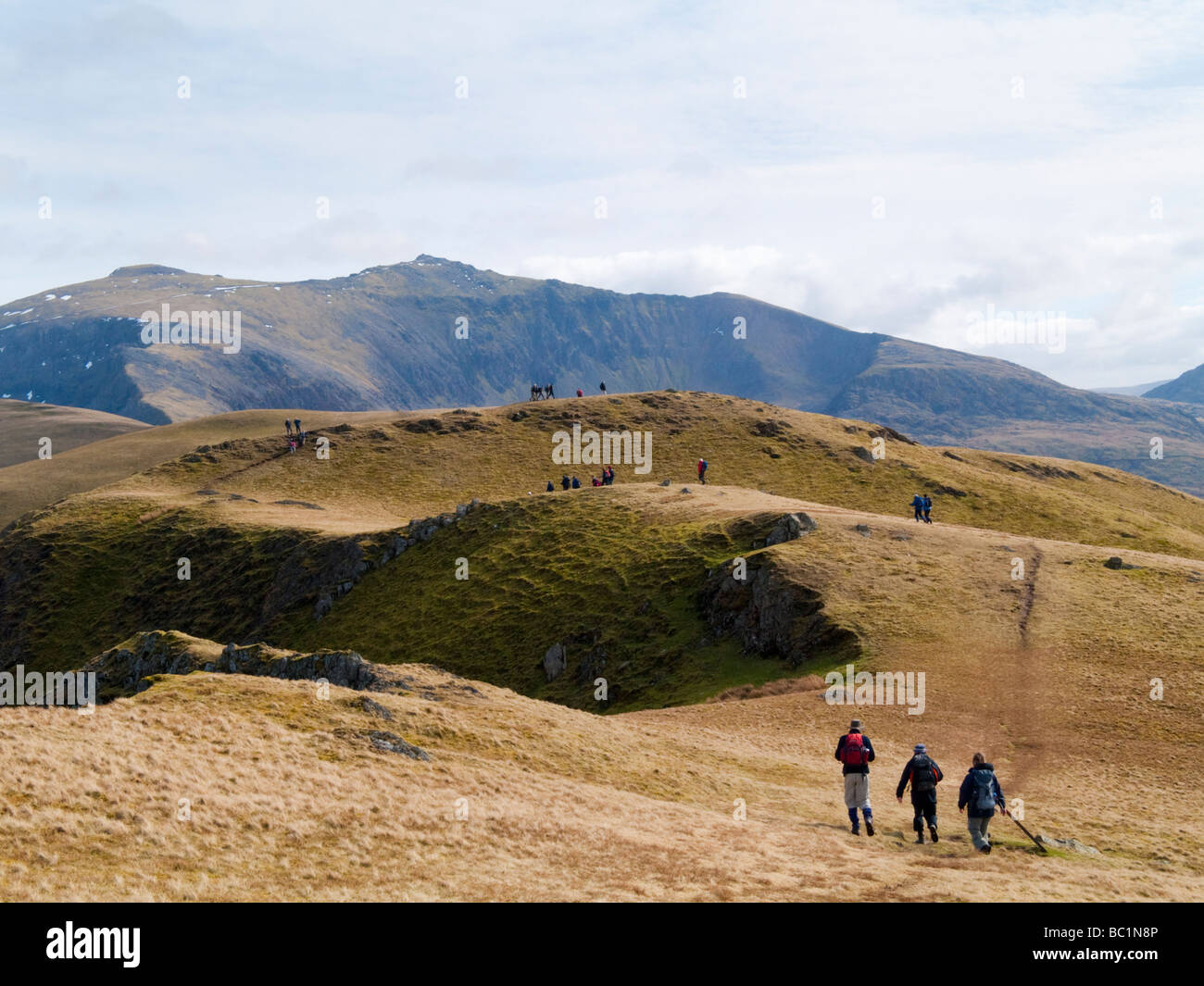 Hikers descending Moel Eilio with Foel Goch and Mount Snowdon beyond in ...