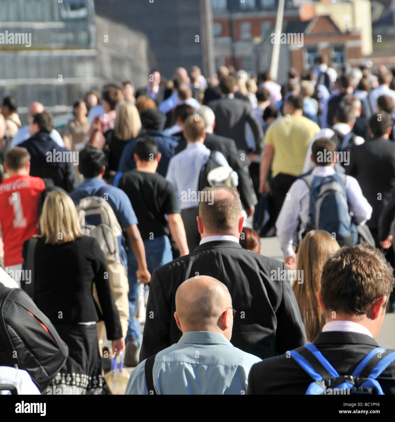Office workers walking across bridge towards London Bridge railway ...
