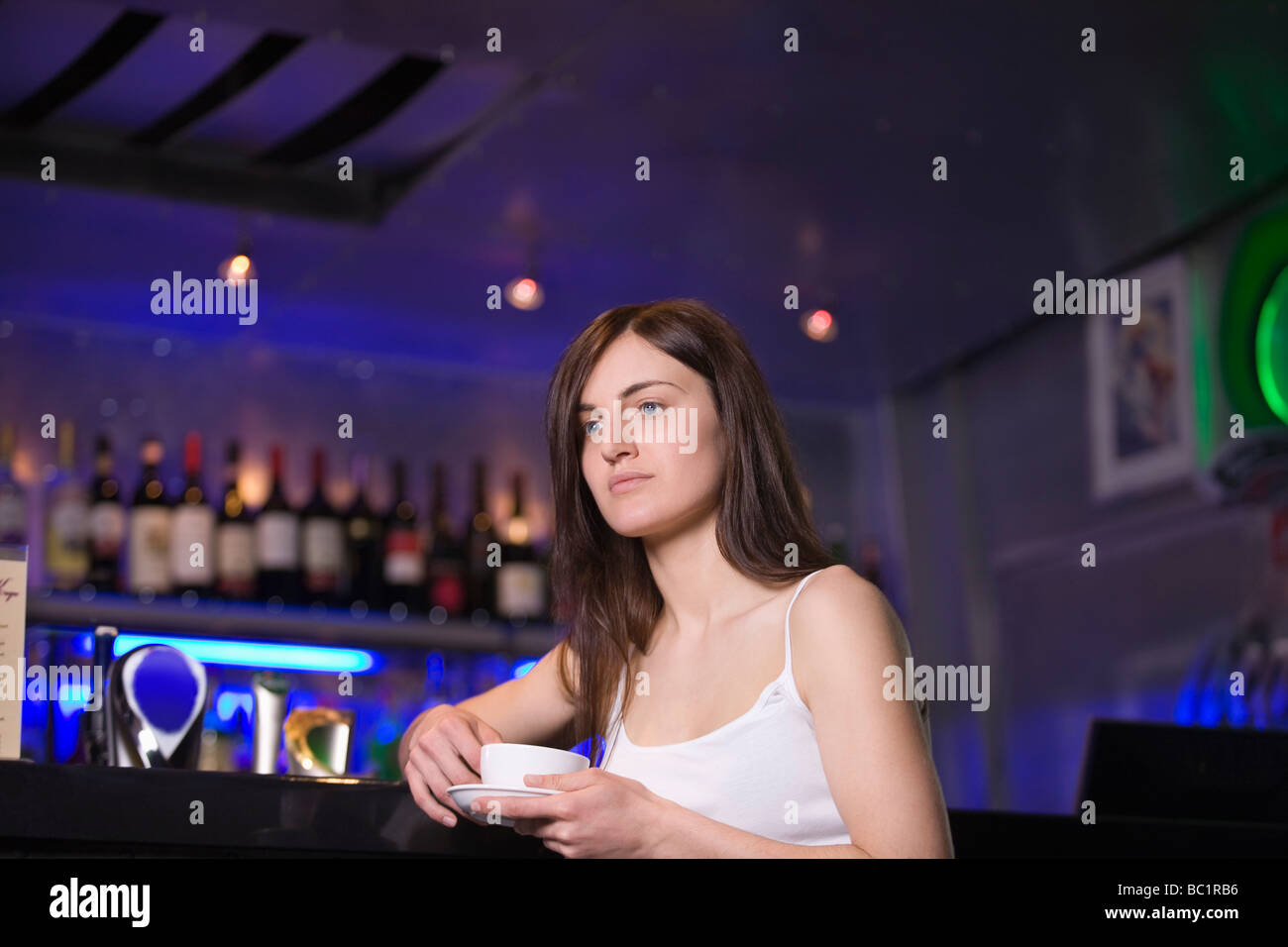 Young woman drinking tea at bar Stock Photo - Alamy