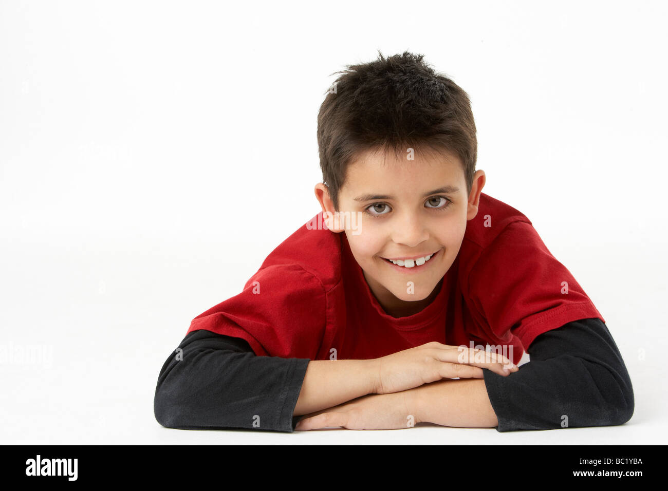 Young Boy Lying On Stomach In Studio Stock Photo - Alamy