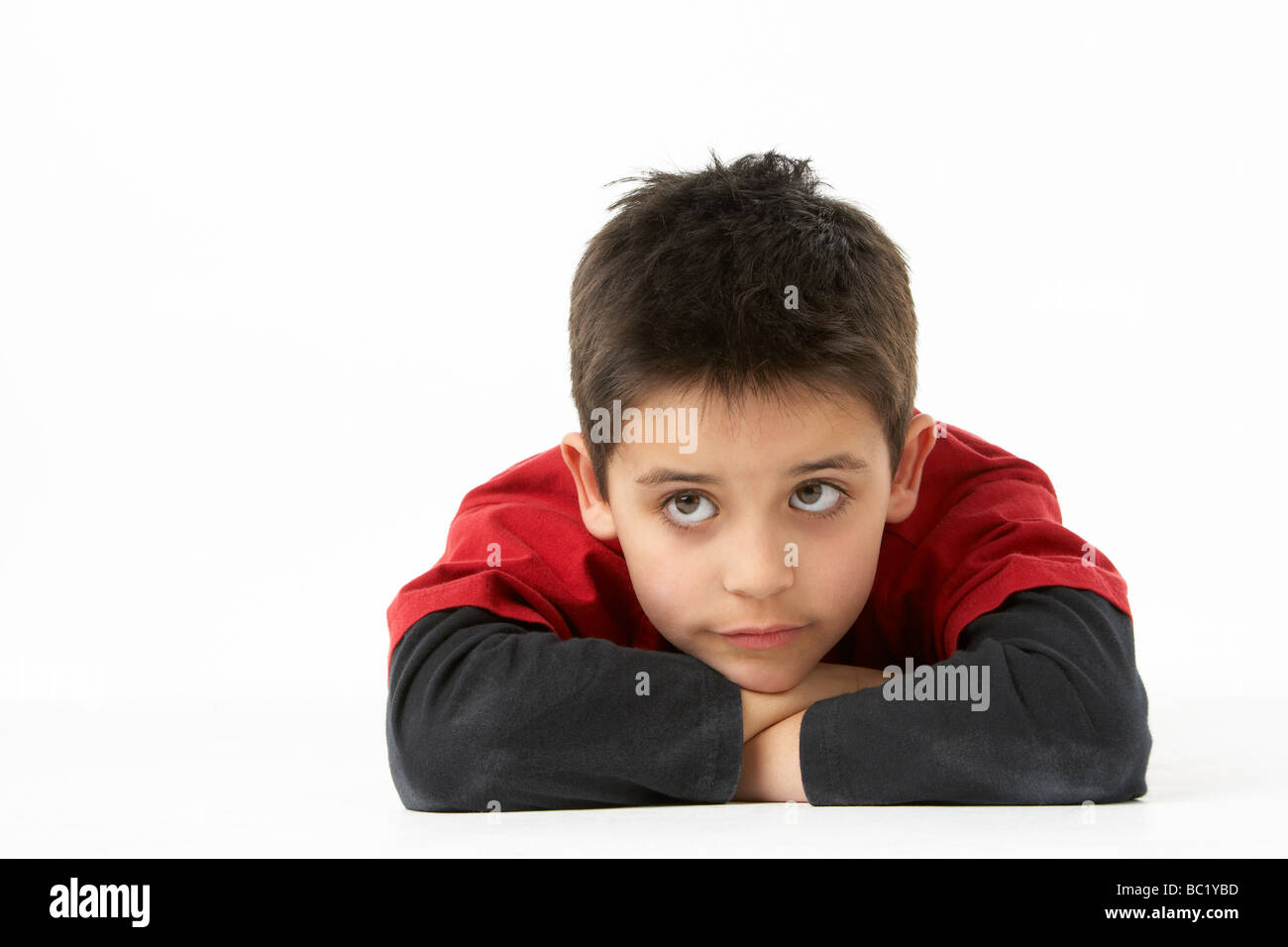Young Boy Lying On Stomach In Studio Stock Photo - Alamy