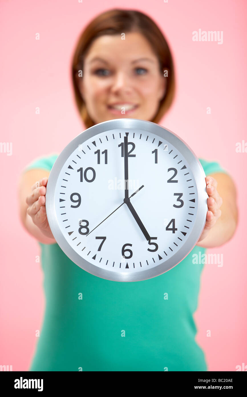 Woman Holding Clock Showing 5 O'Clock Stock Photo - Alamy