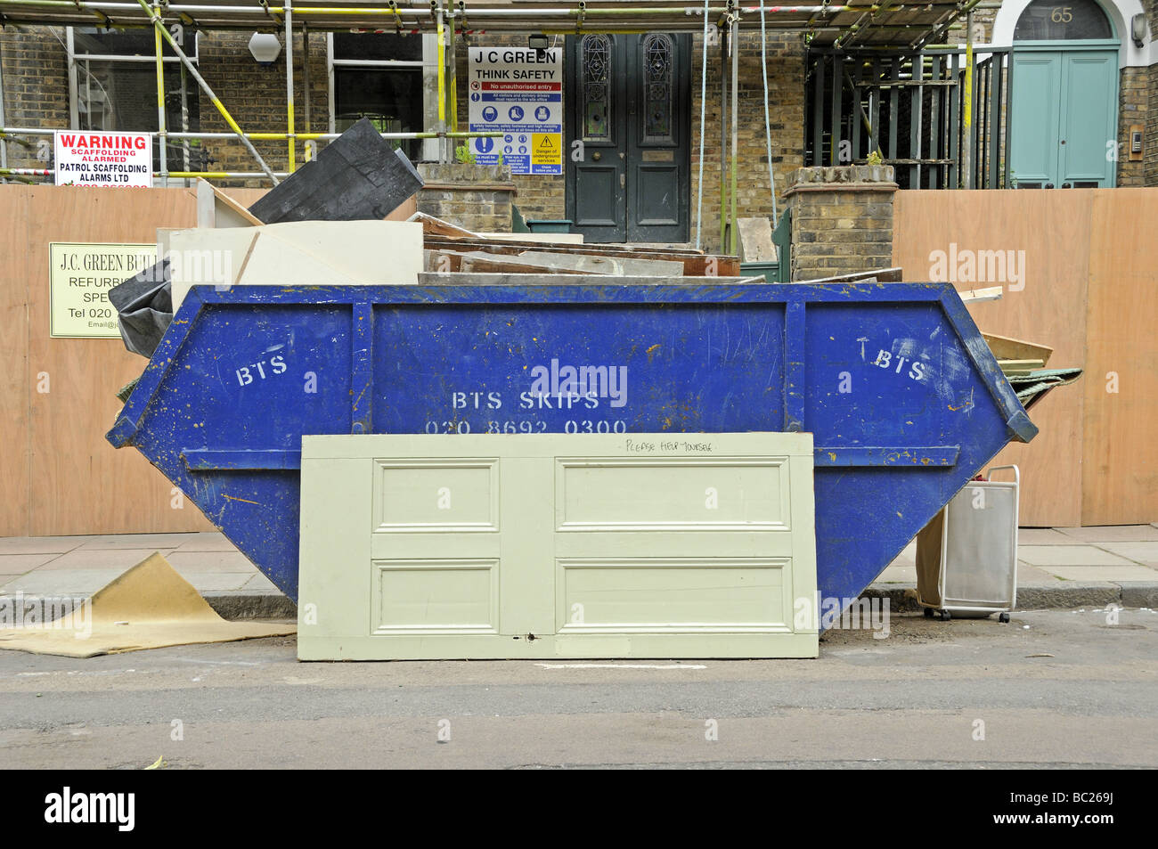 Skip with old door offered for recycling leaning against the side Stock ...