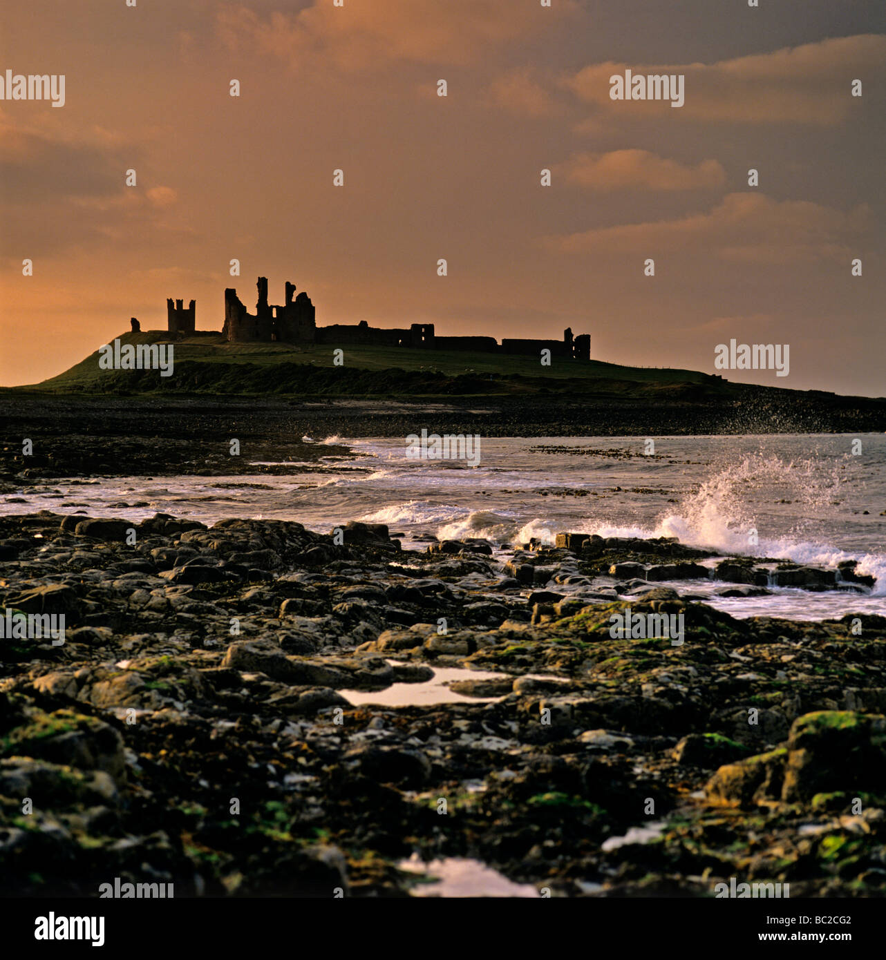 Dunstanburgh Castle a view at sunset of the commanding ruins on basalt ...