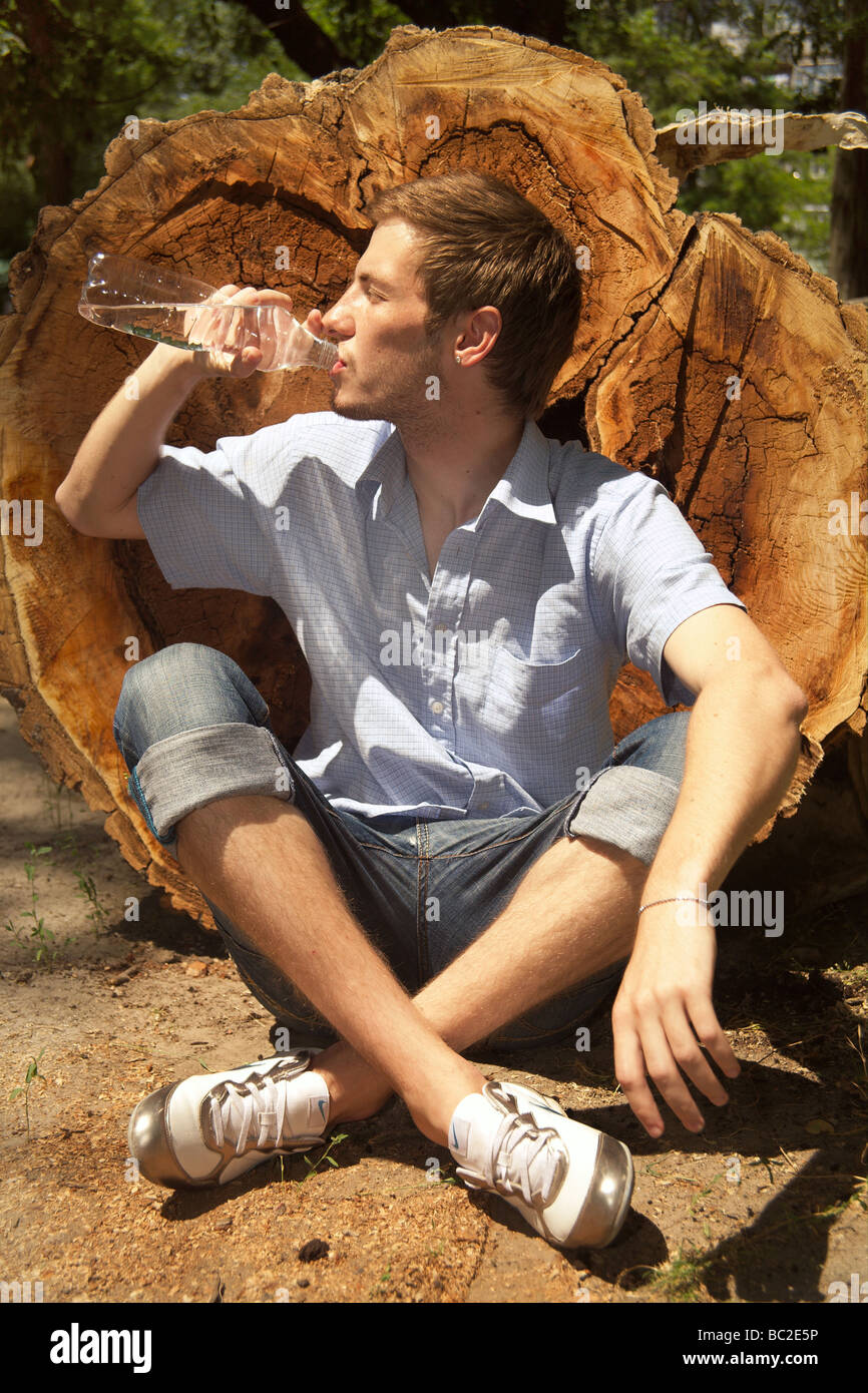 The young guy drinks water from a bottle Stock Photo - Alamy