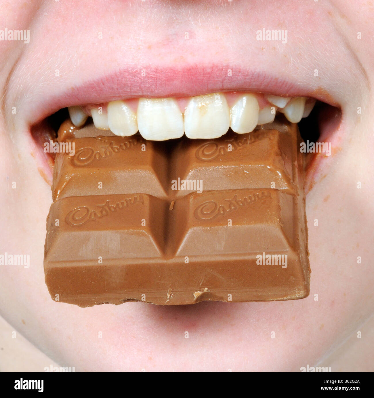Schoolgirl eating a chocolate bar Stock Photo - Alamy