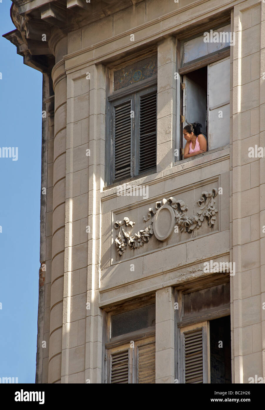 Cuban woman peering from the window of a colonial building in Old ...