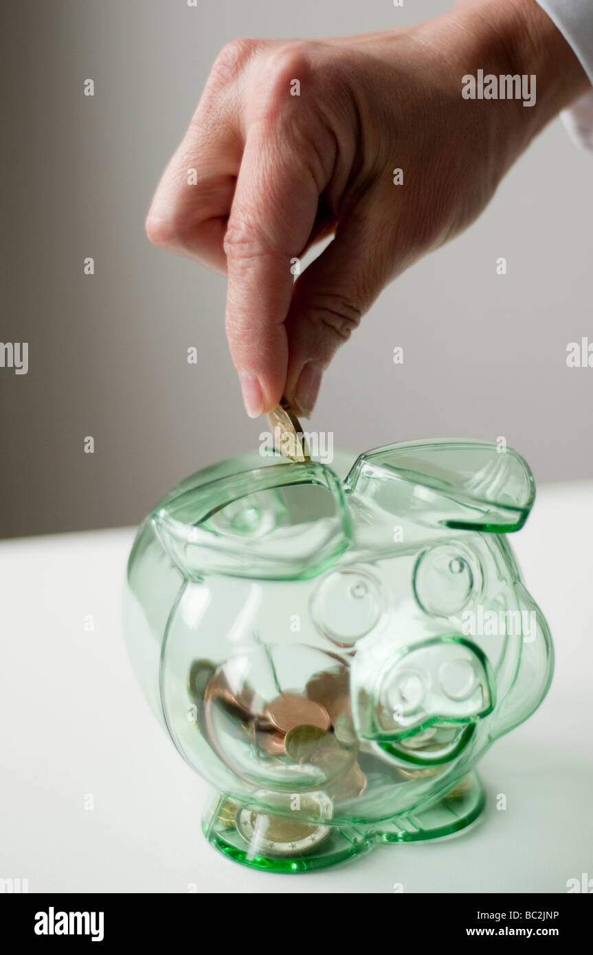 Hand dropping coins hi-res stock photography and images - Alamy