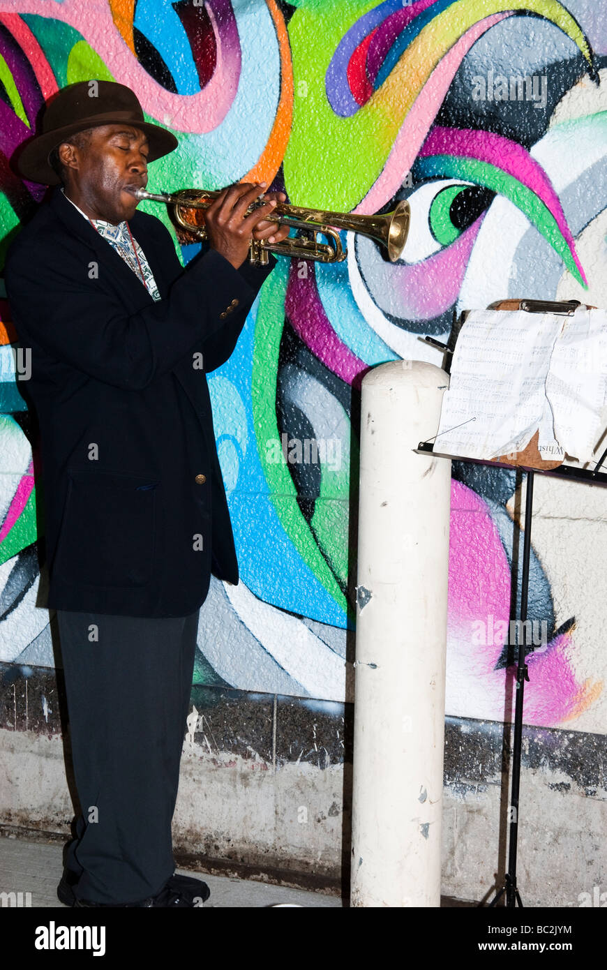 a street performer playing a trumpet in an urban setting with a ...