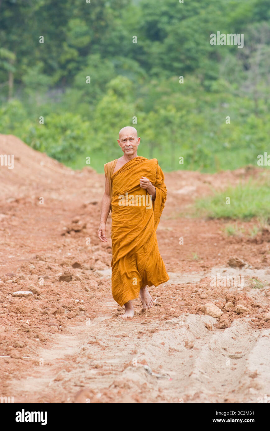 Buddhist monk walking barefoot on a dirt road Stock Photo - Alamy