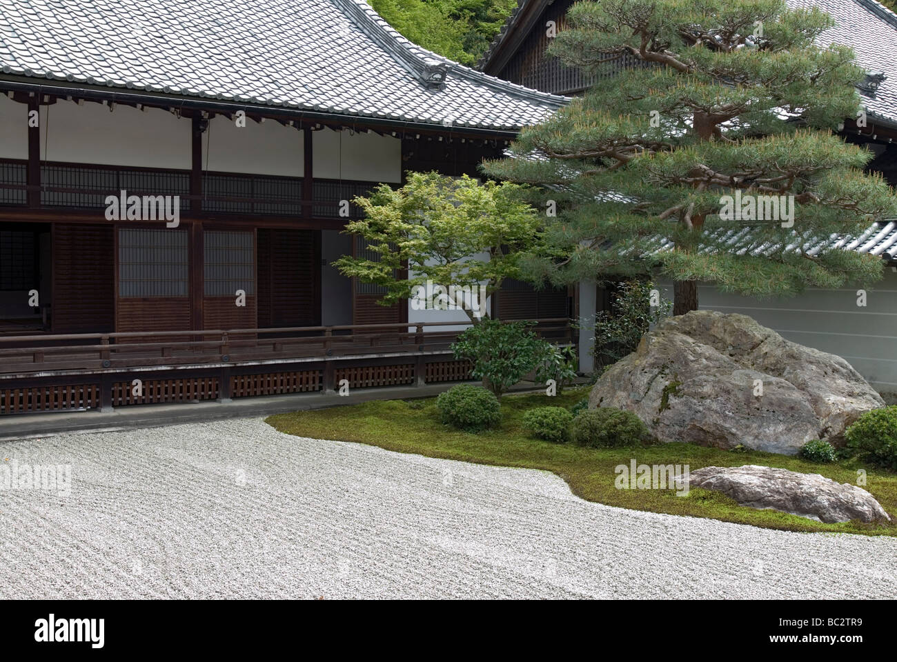 A stately pine tree and boulder form the focal point of this raked ...