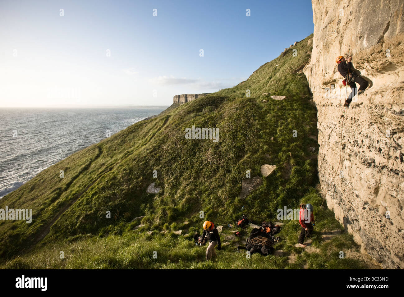 Rock climber sport climbing on a limestone cliff next to the sea Stock ...