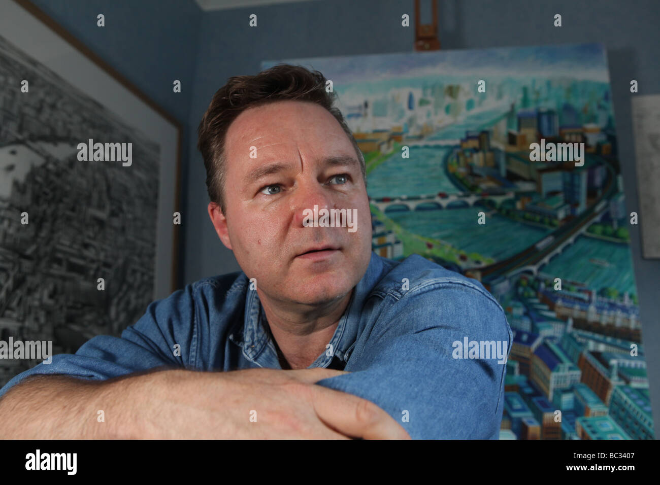 a portrait of a famous artist sitting in front of his most recent piece ...