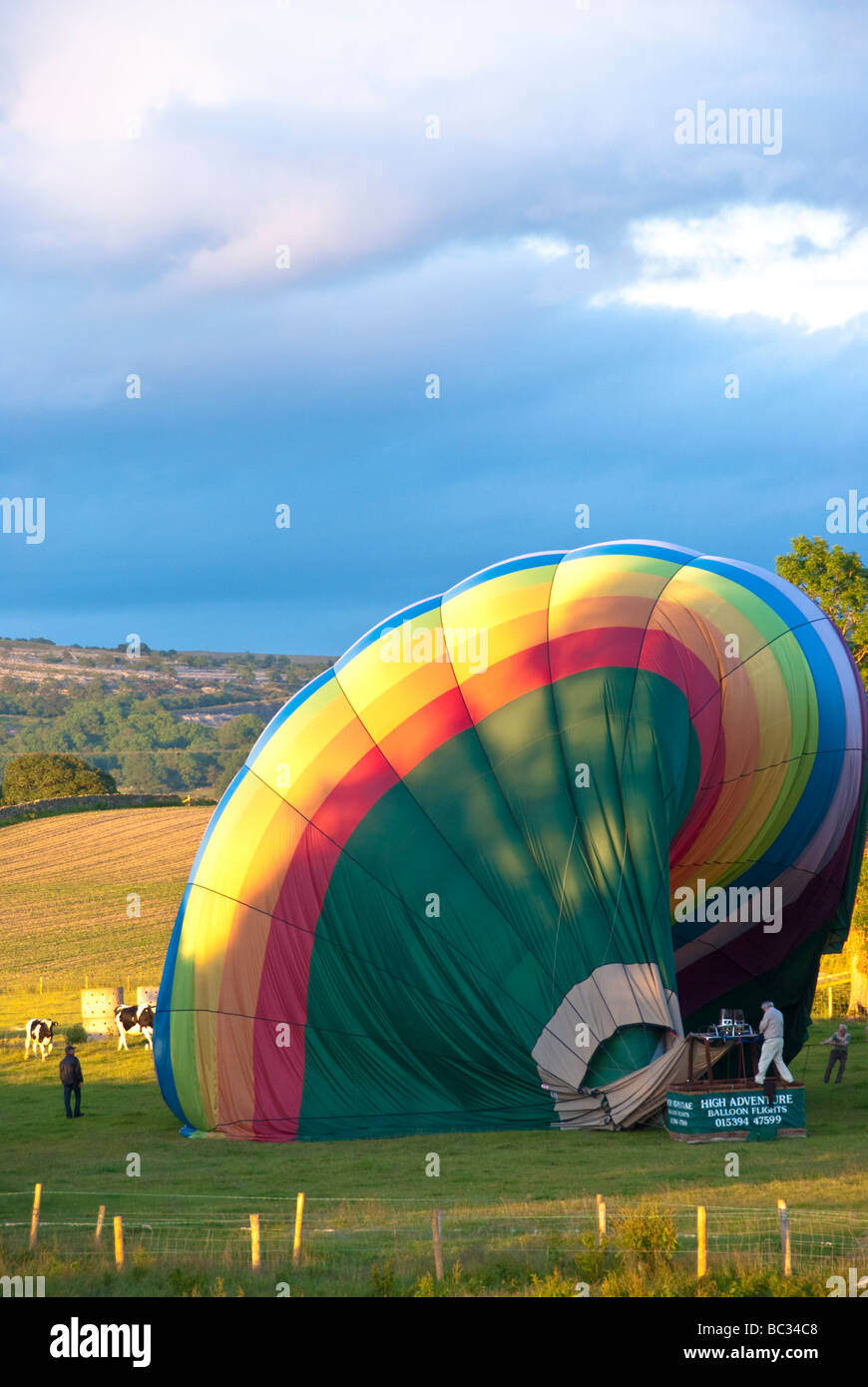 hot air balloon landing in field Stock Photo - Alamy