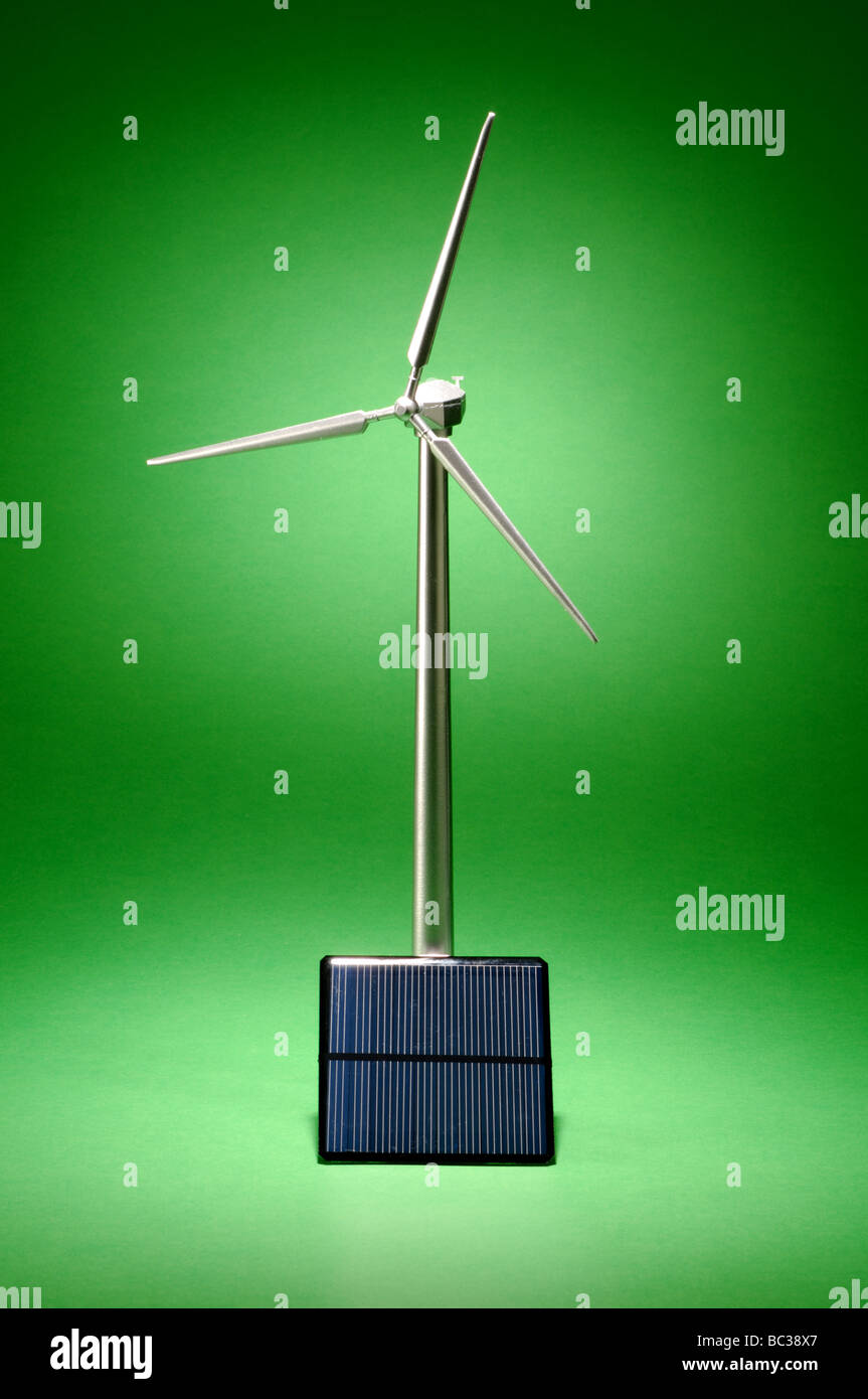 A small metal wind turbine on a green background with a small solar ...