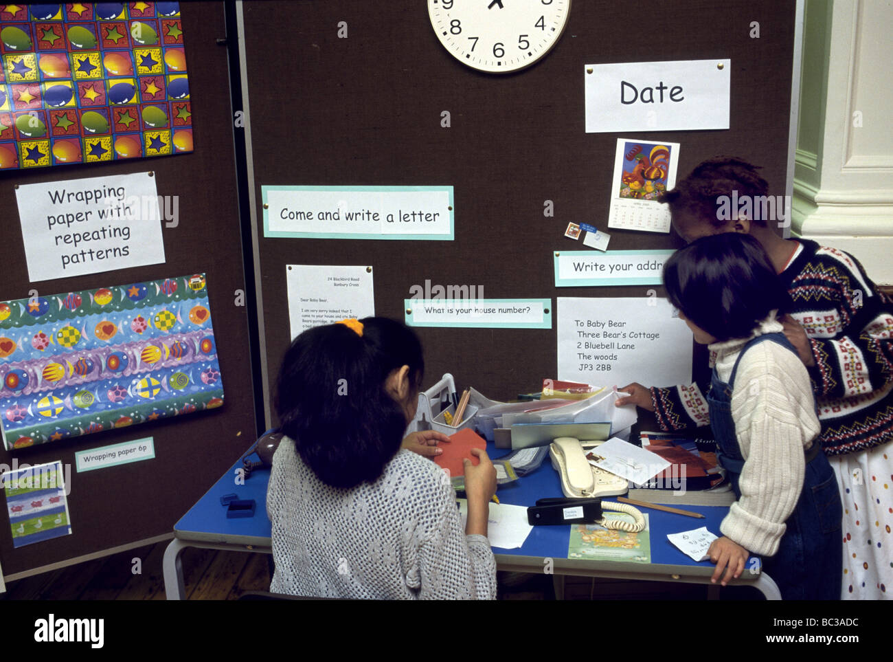 primary school children playing at a math activity corner in classroom ...