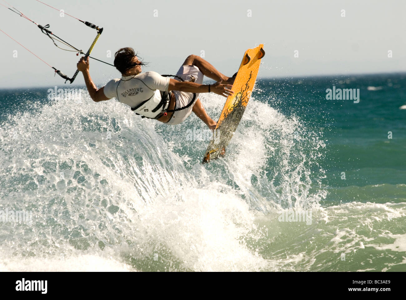 Kite surfer grabbing side of board while catching air Stock Photo - Alamy