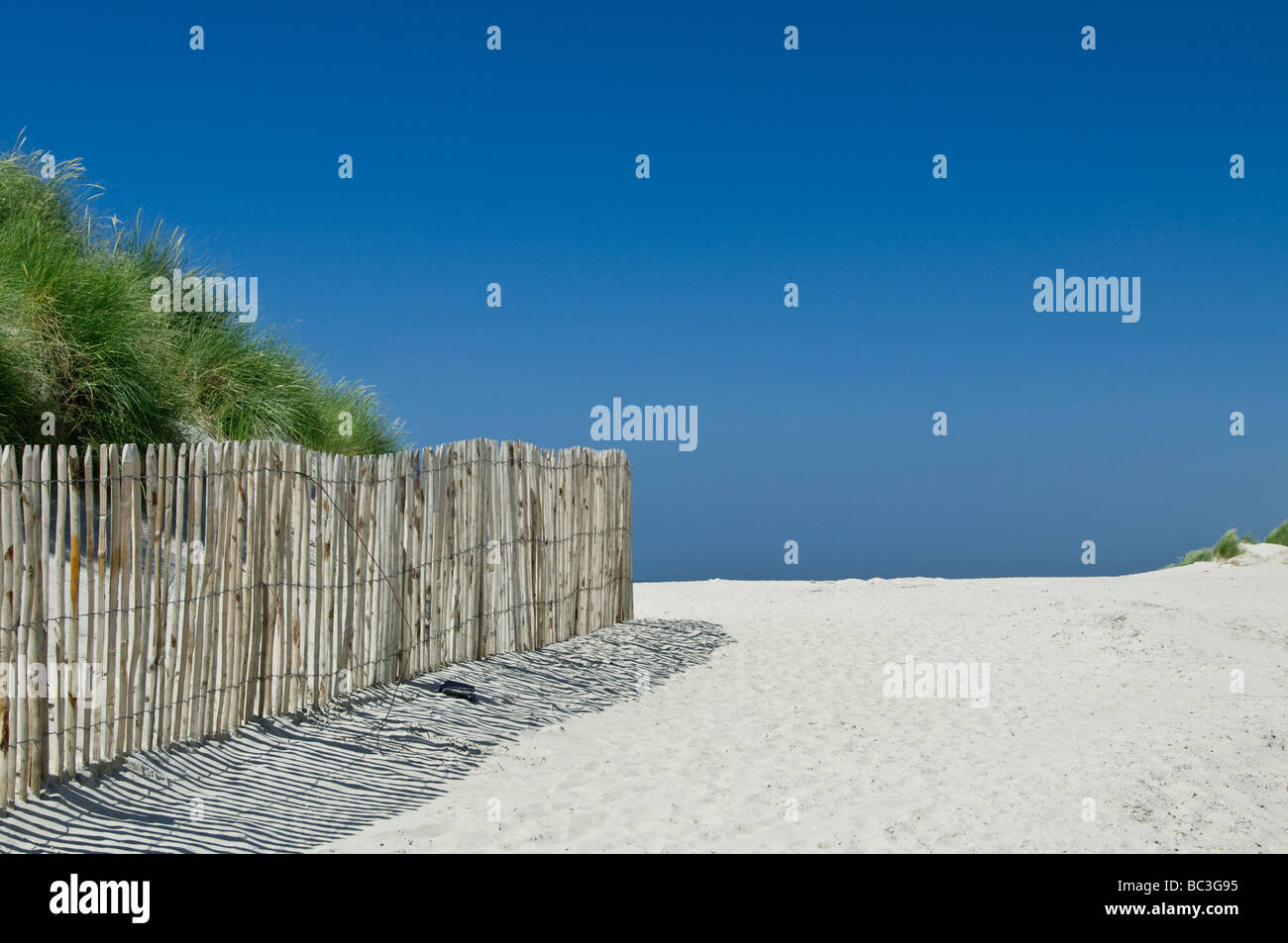 Concept generic image of simple wooden fence and white coastal sand ...