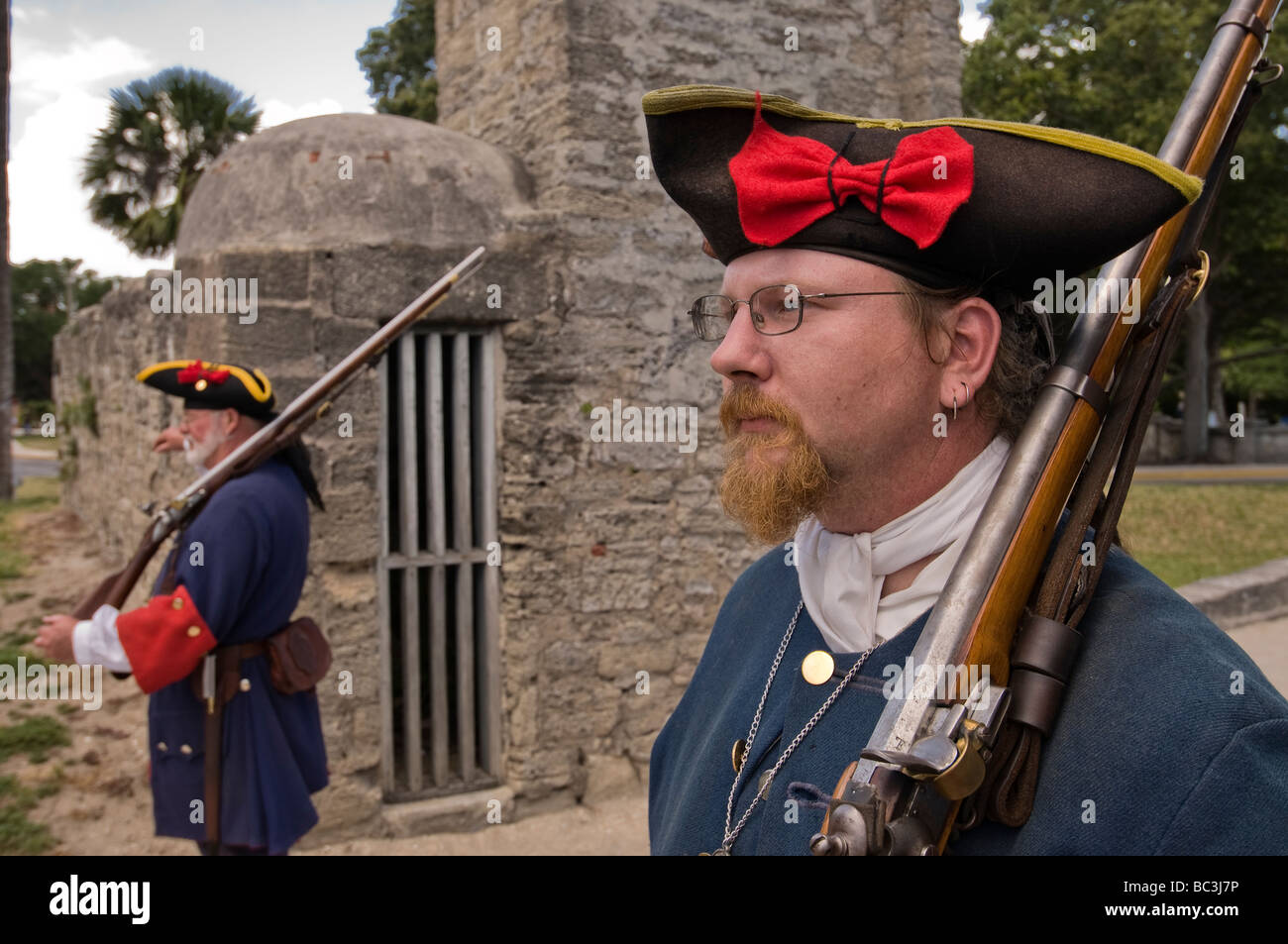 Actors in 18th century Spanish army uniforms carry flintlock rifles as ...