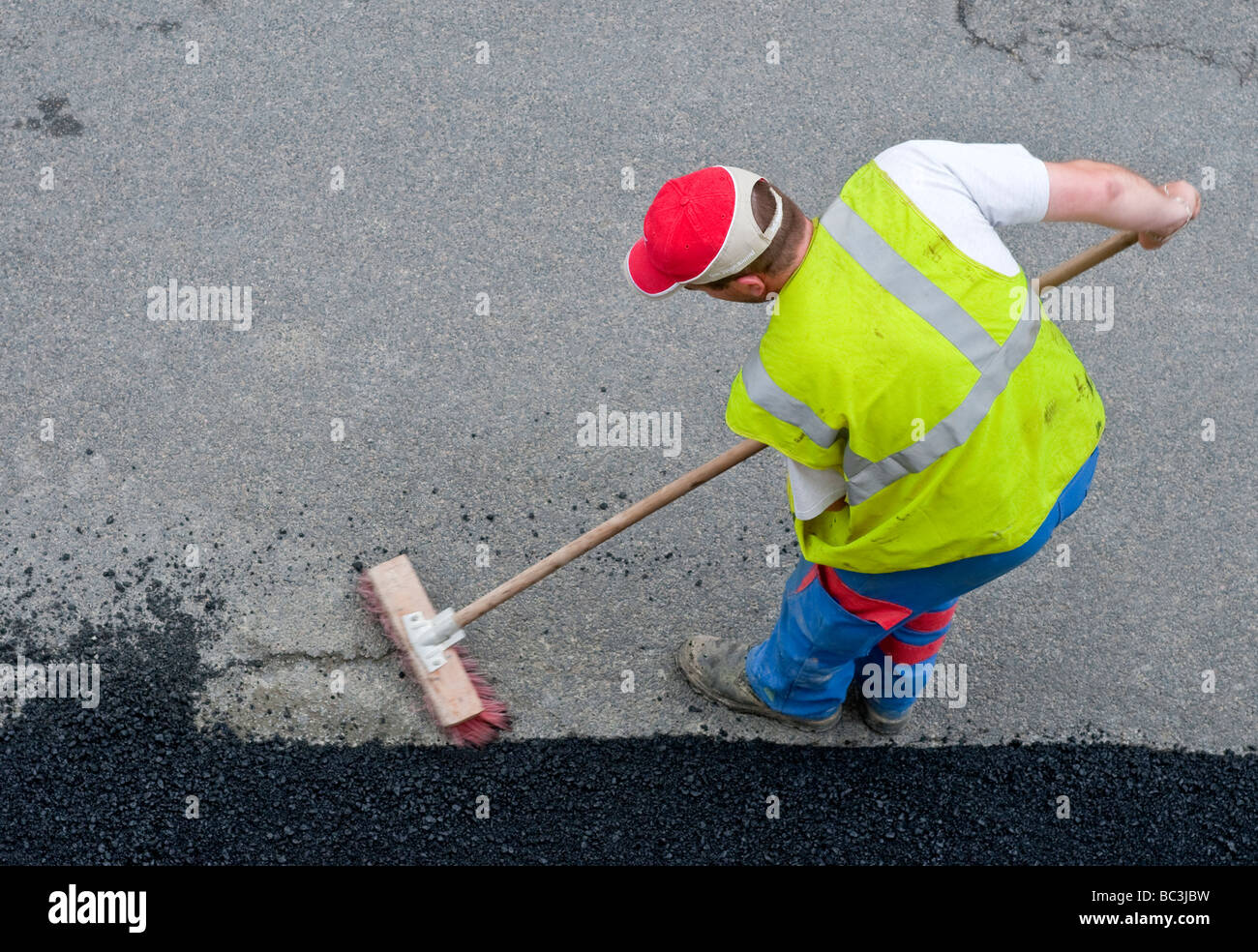 Road works contractor brushing tarmac before rolling - France Stock ...