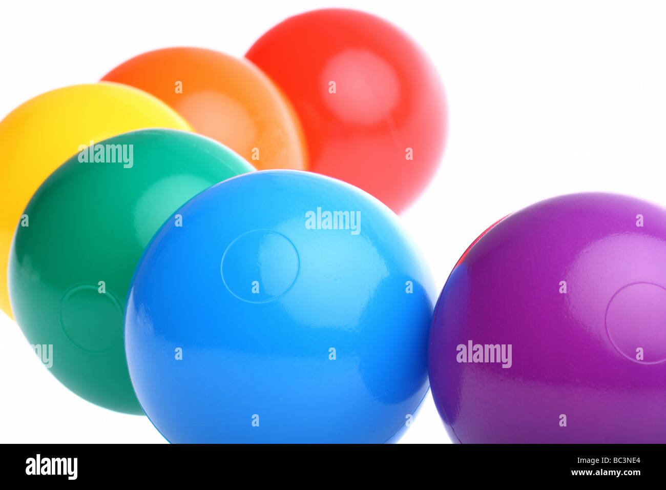 Six shiny coloured plastic toy balls isolated on white. Copy space and ...