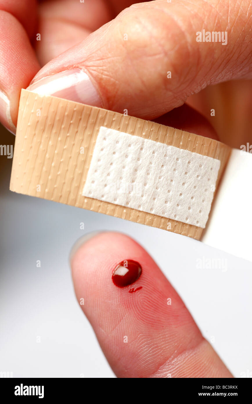 Plaster applyed to a little wound on a finger Stock Photo - Alamy