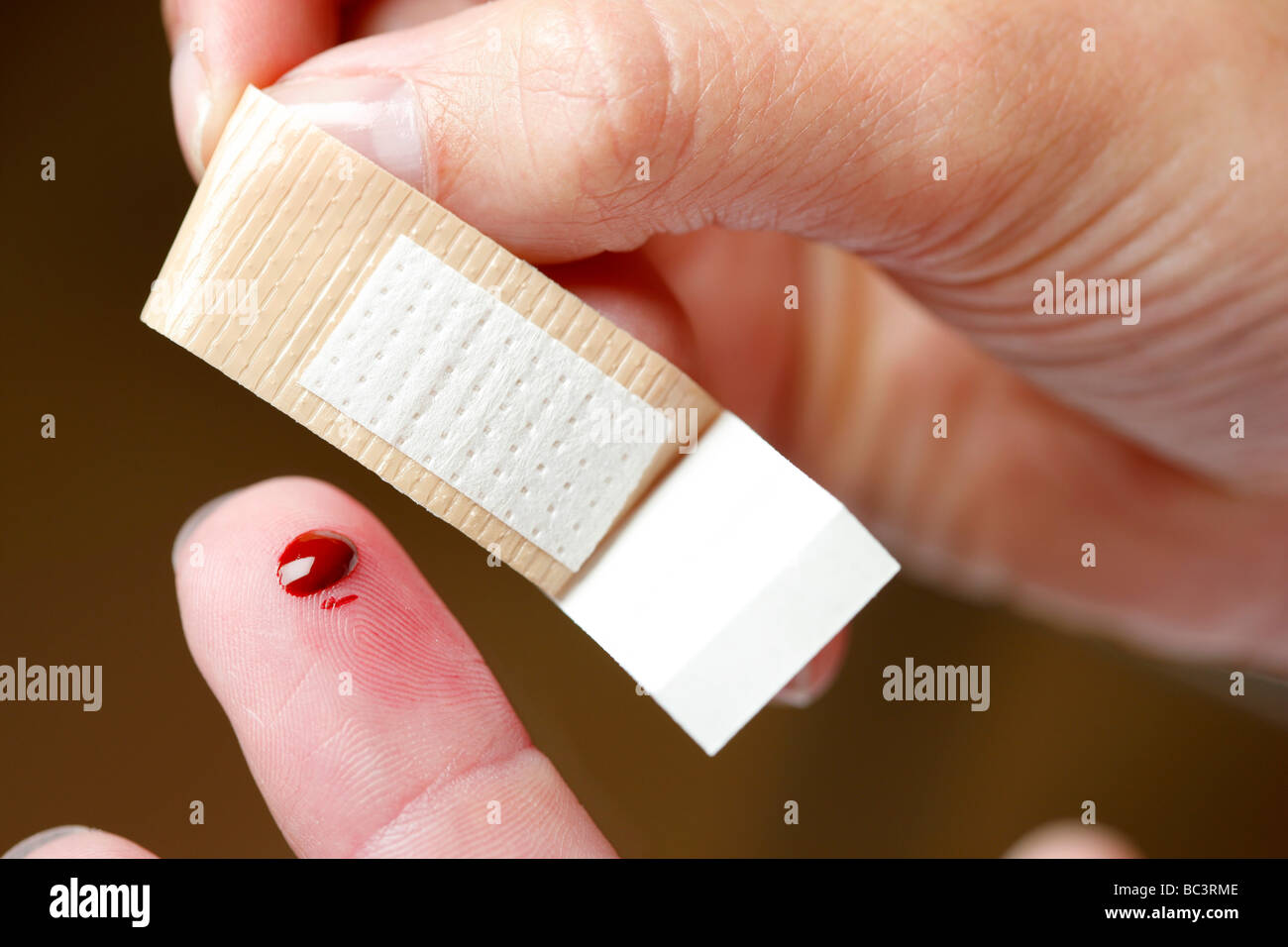 Plaster applyed to a little wound on a finger Stock Photo - Alamy