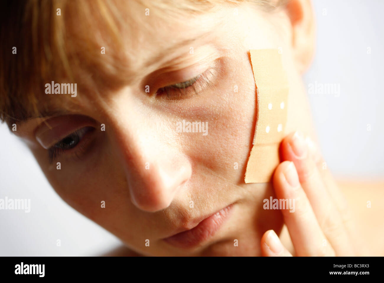 Woman has a plaster on her face Stock Photo - Alamy