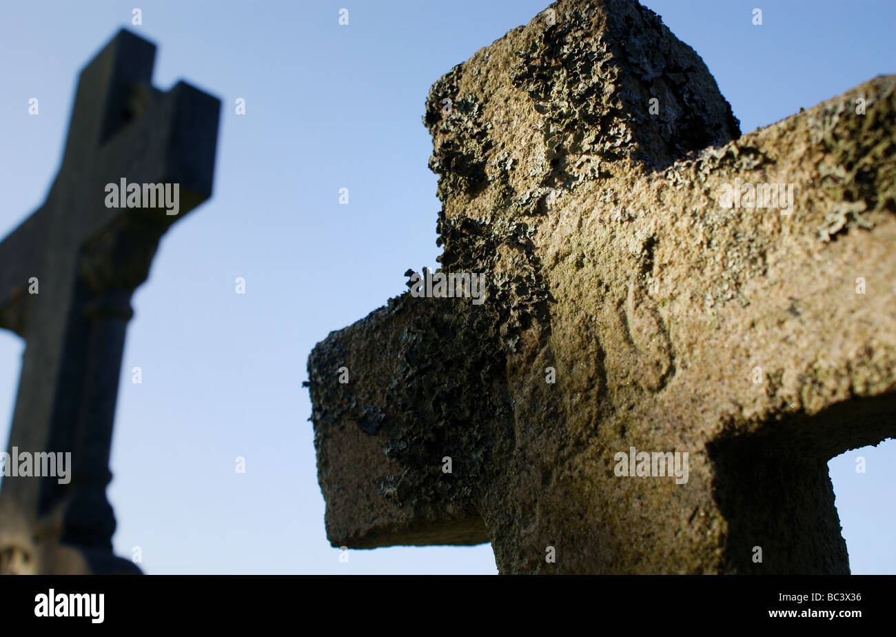 Up close stone cross from Crantock graveyard with shadow, blue sky and ...
