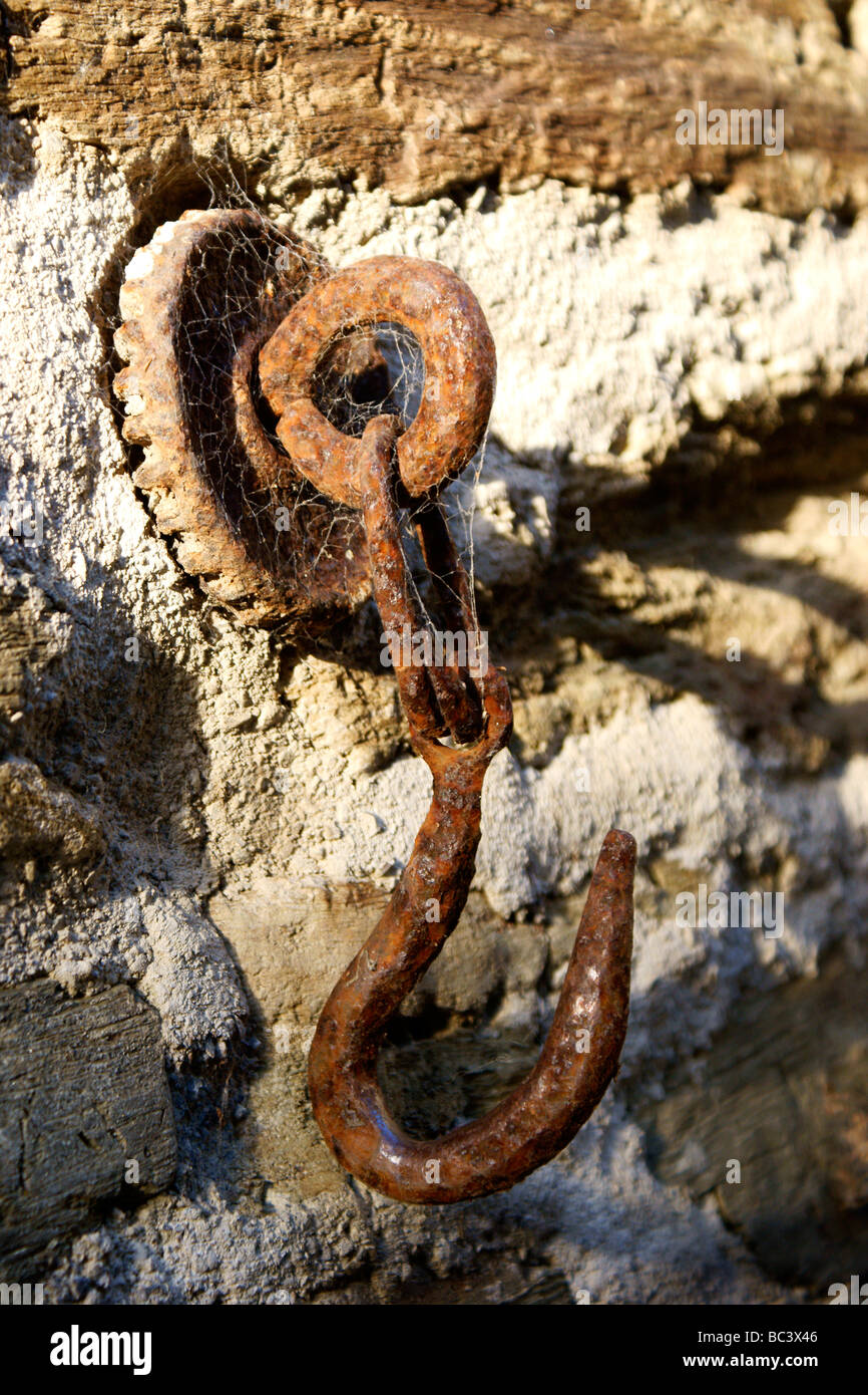Rusty old hook covered in tiny cobwebs hanging from a stone wall Stock ...