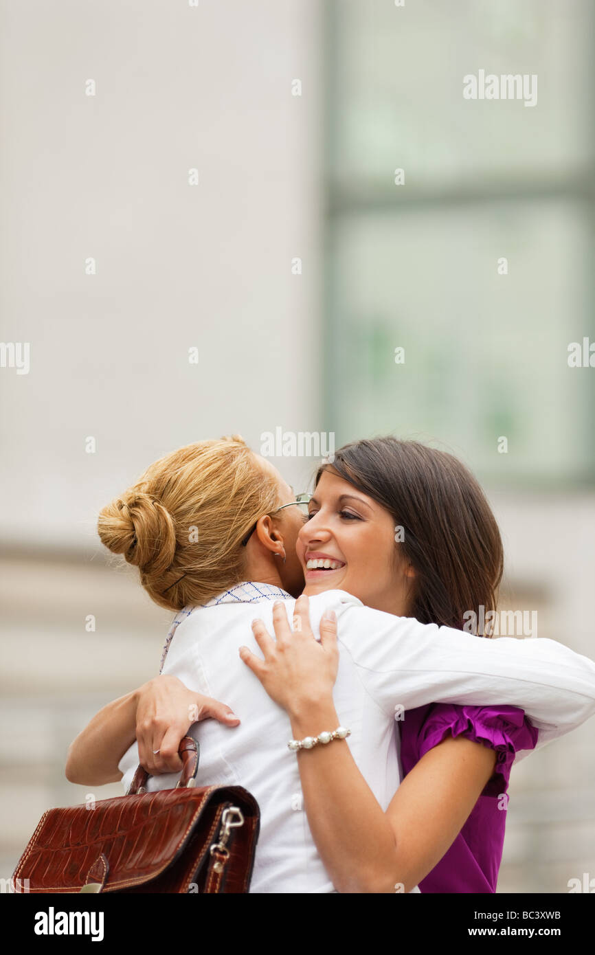 two female colleagues hugging outdoors Stock Photo - Alamy