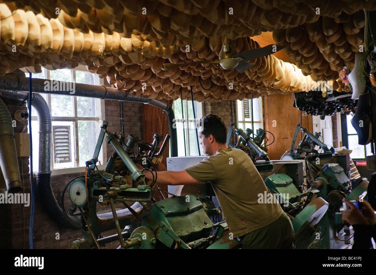 Clogmaker operates woodworking machine in a clog factory Stock Photo ...
