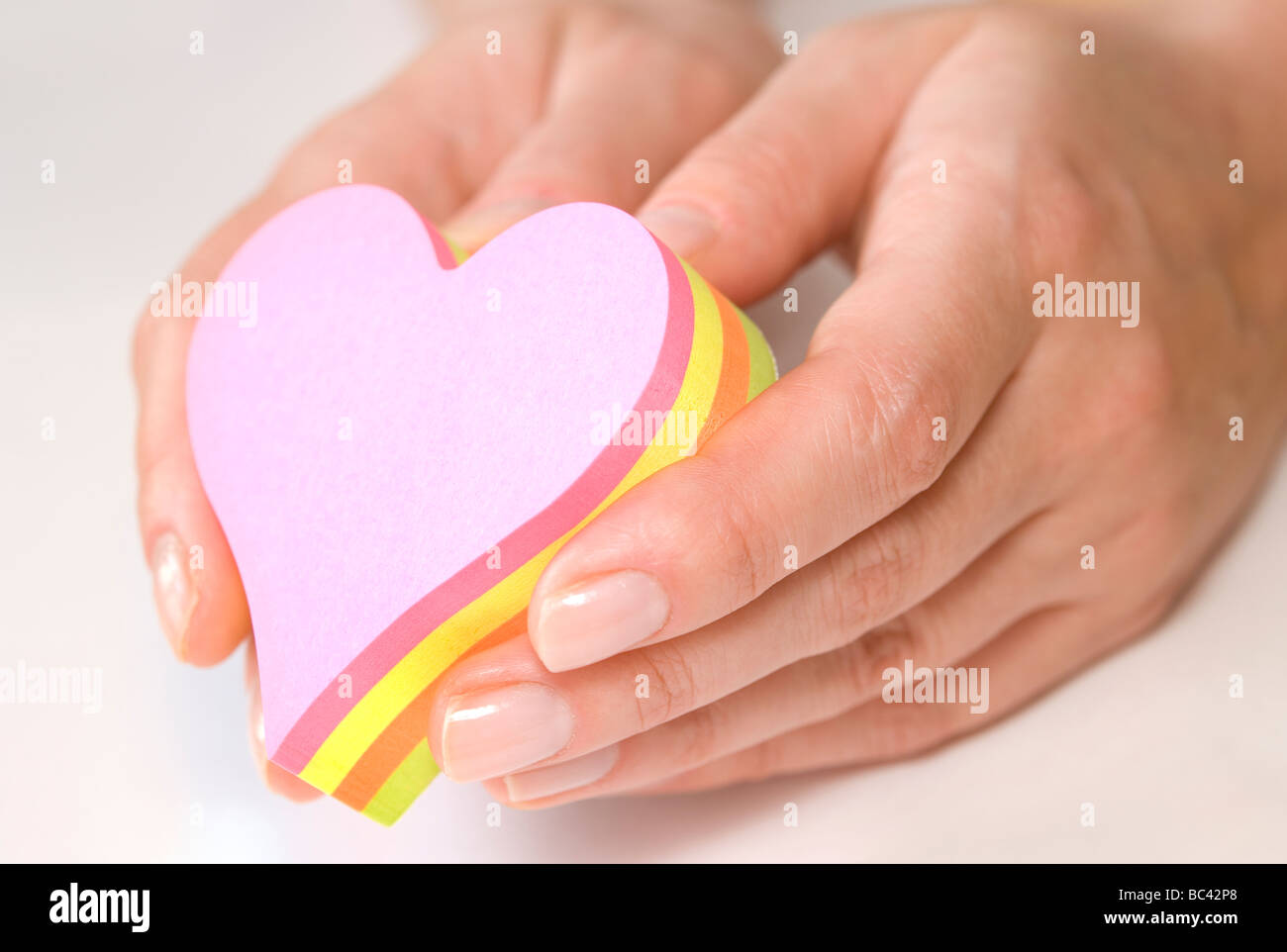 Hands holding heart shaped colorful sticky notes Stock Photo - Alamy