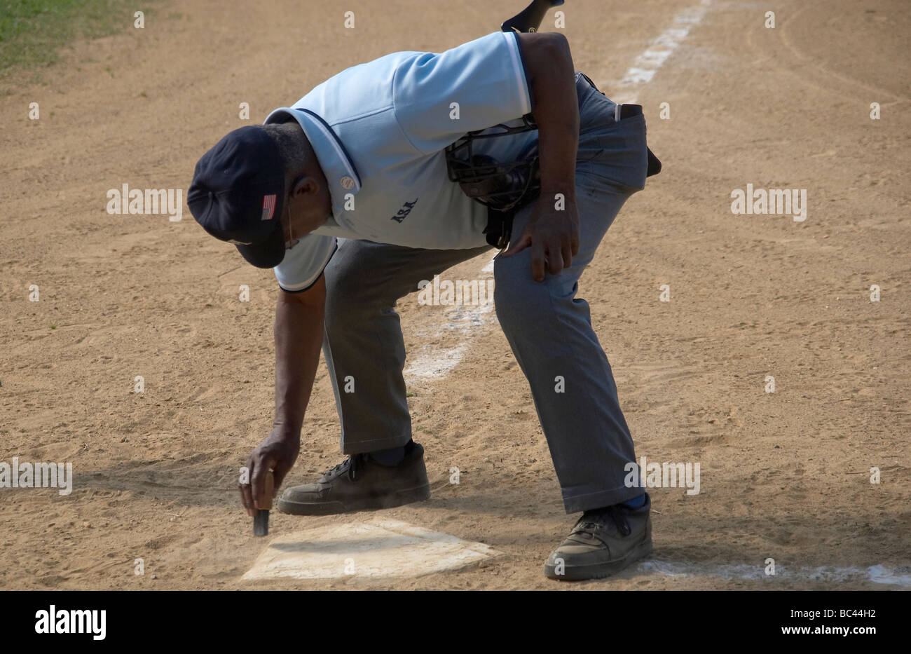 umpire cleaning the home plate Stock Photo - Alamy