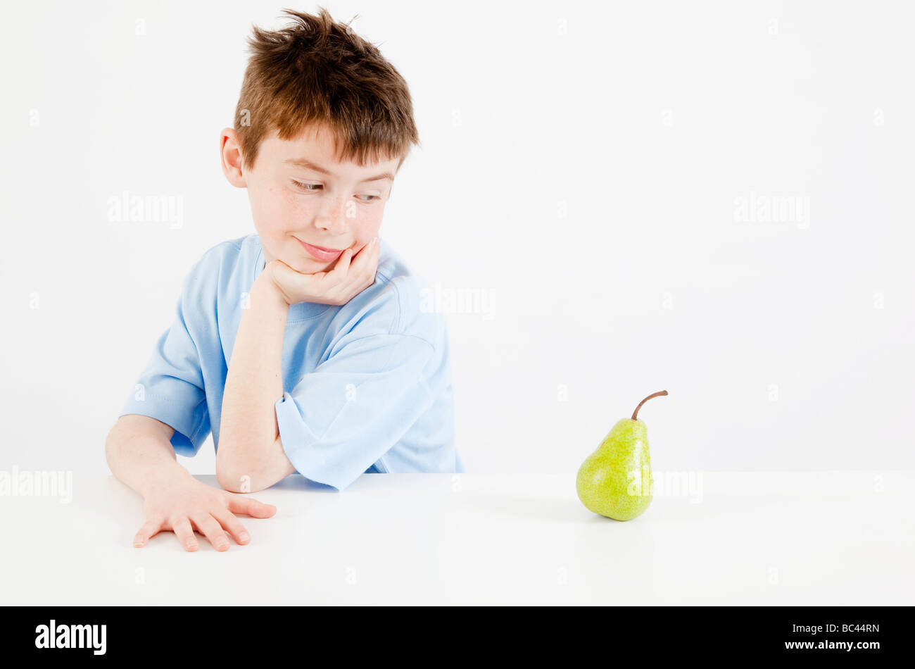 Male child contemplating a pear Stock Photo - Alamy