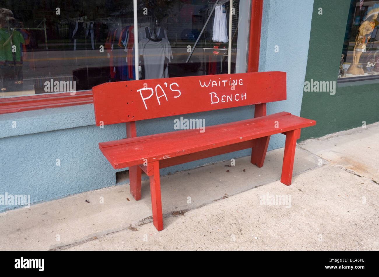 Shoppers waiting bench for men on sidewalk outside store in High ...