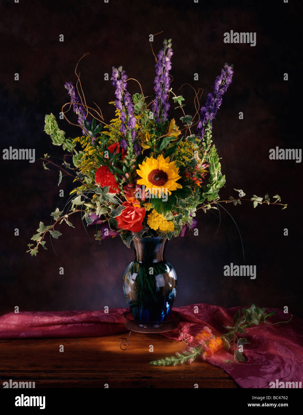 Blue Vase with flower arrangement on wooden table Stock Photo - Alamy