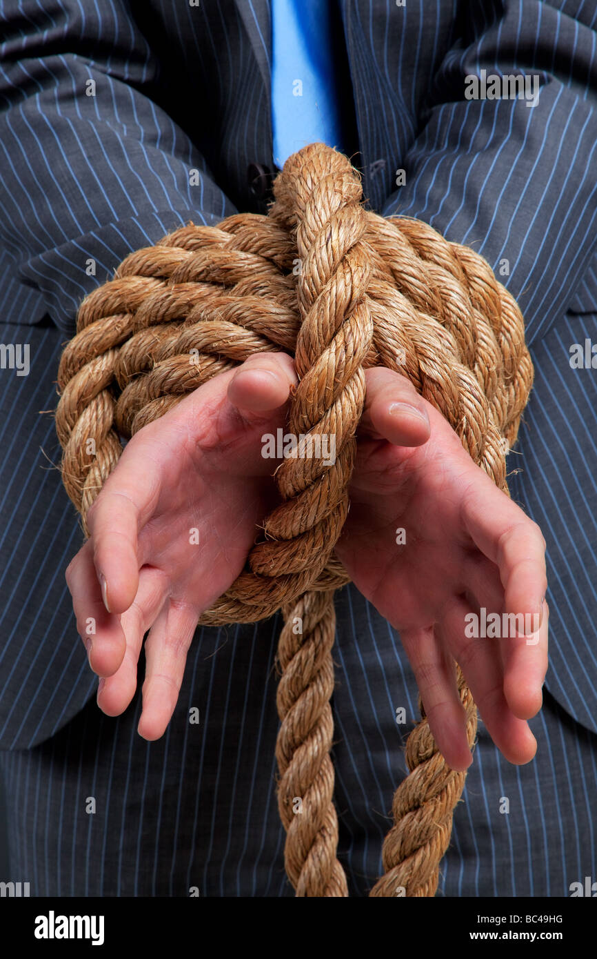 Close up of a businessmans hands tied with rope Stock Photo - Alamy