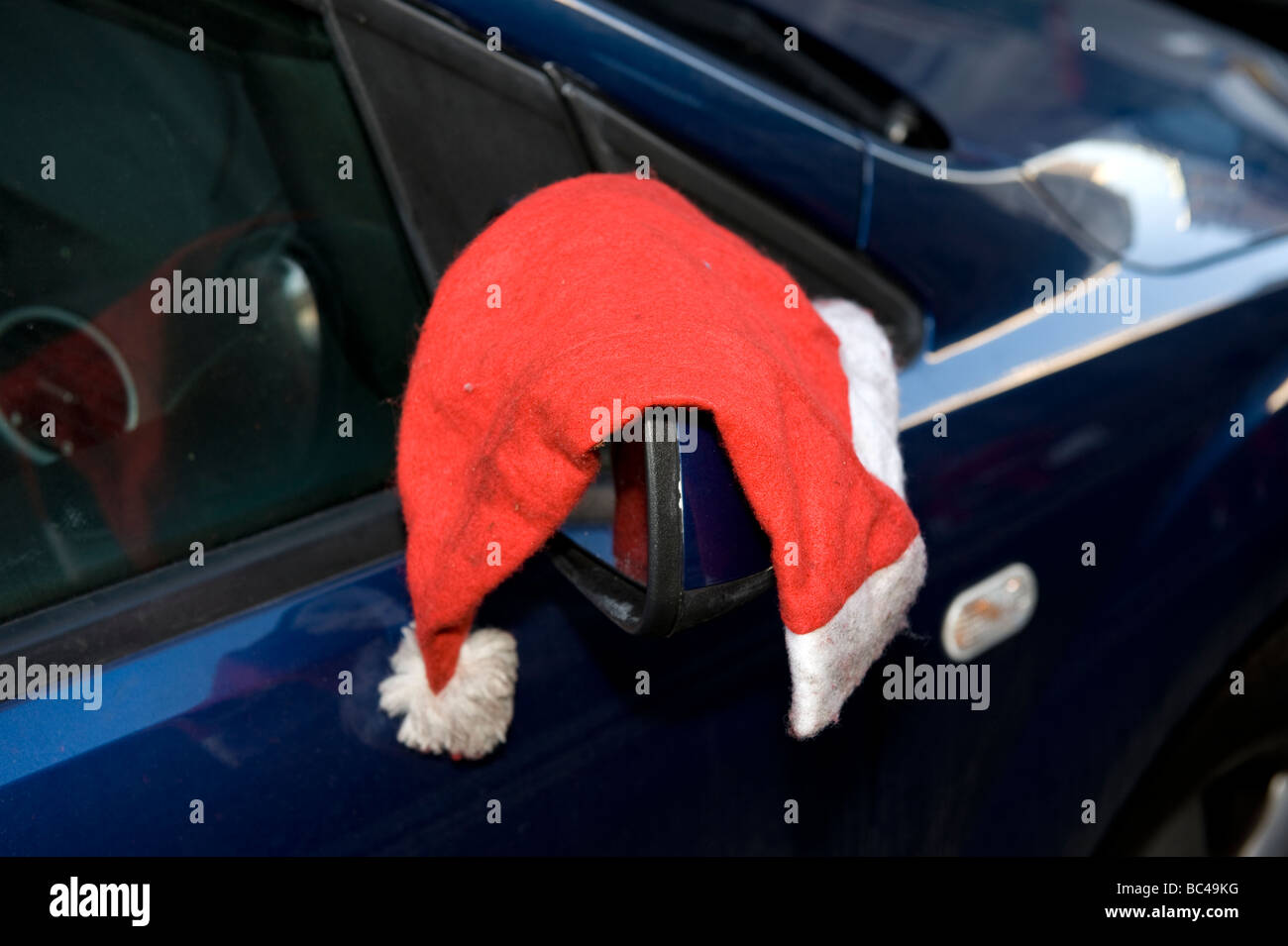 Father Christmas red hat discarded on wing mirror of parked car by ...