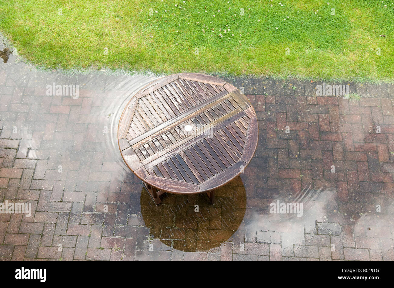 Flooded patio with wooden table during summer storms and flash flooding ...