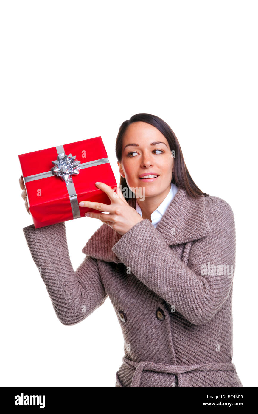 Brunette woman shaking her present to see whats inside isolated on a ...