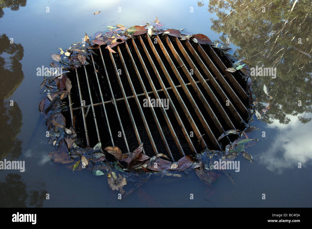 DRAINAGE GRATE IN LAKE WITH SKY REFLECTION Stock Photo - Alamy