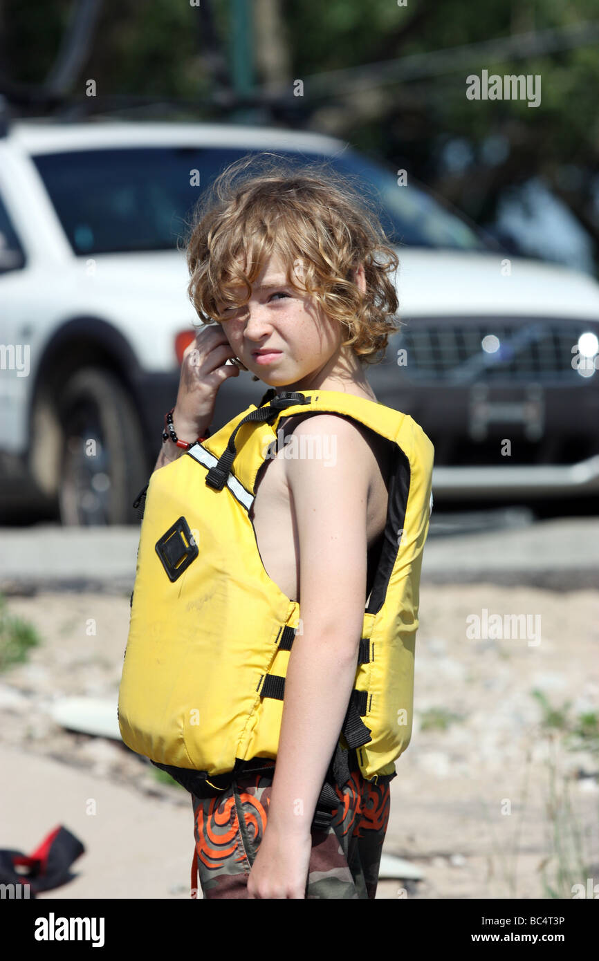 Young boy standing at beach wearing life jacket Stock Photo - Alamy