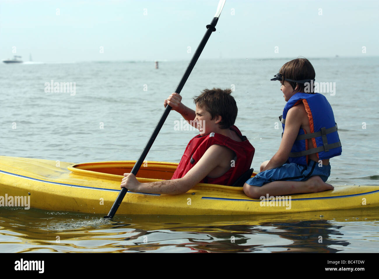 Young boys playing on a kayak Stock Photo - Alamy
