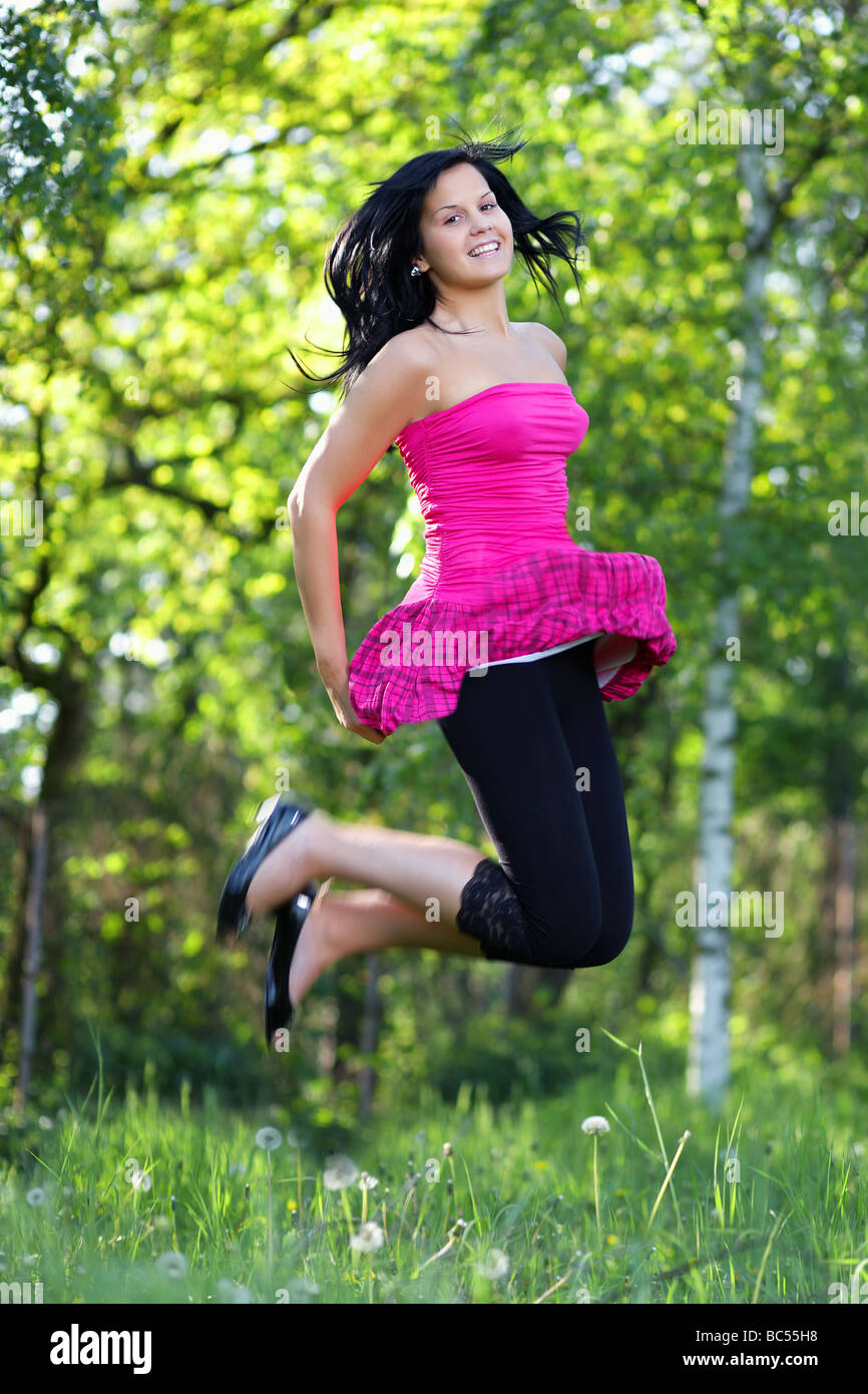 Young woman jumping in the garden Stock Photo - Alamy