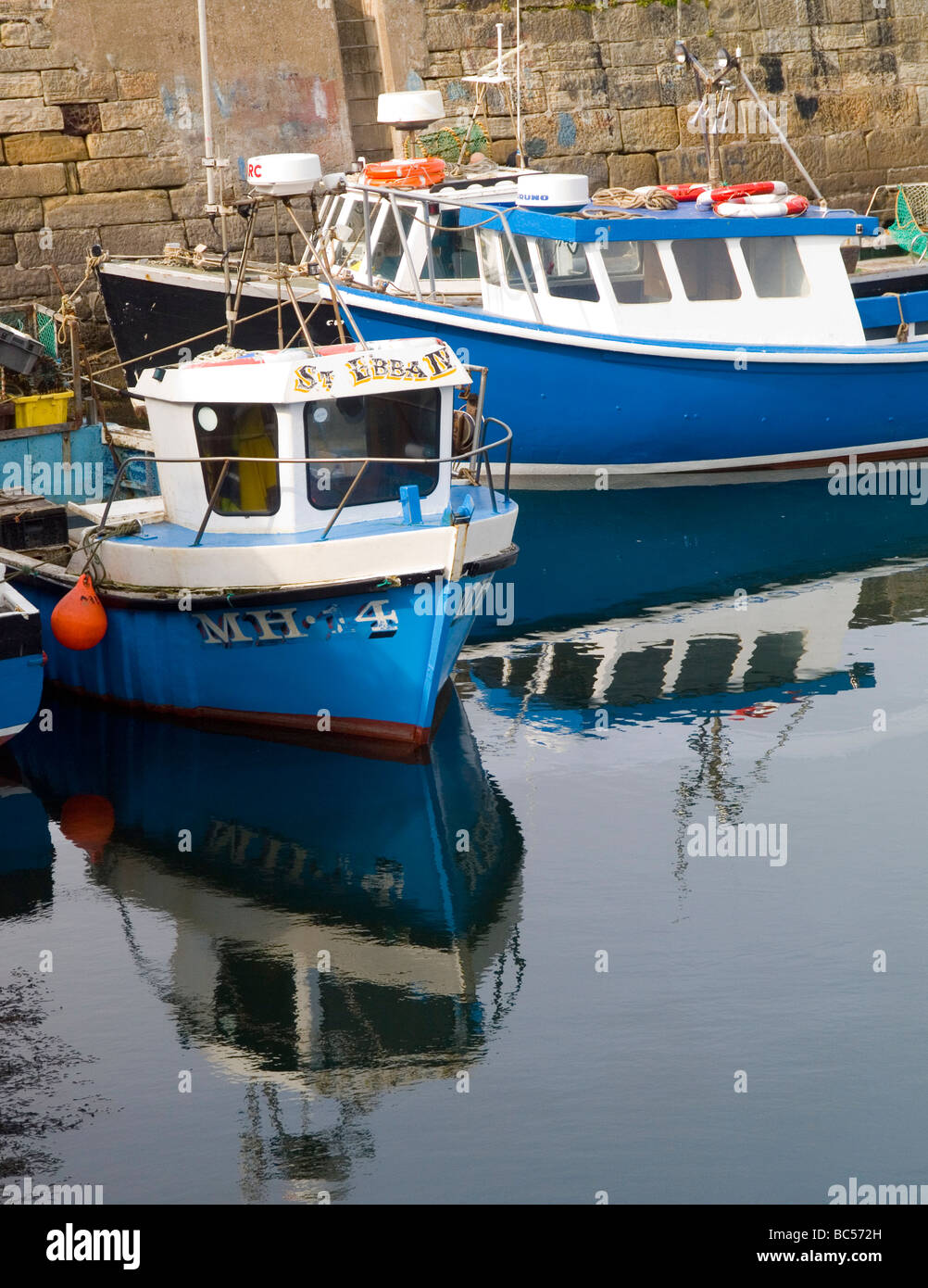 Boats in the harbour of St Abbs, a pretty fishing village on the coast ...