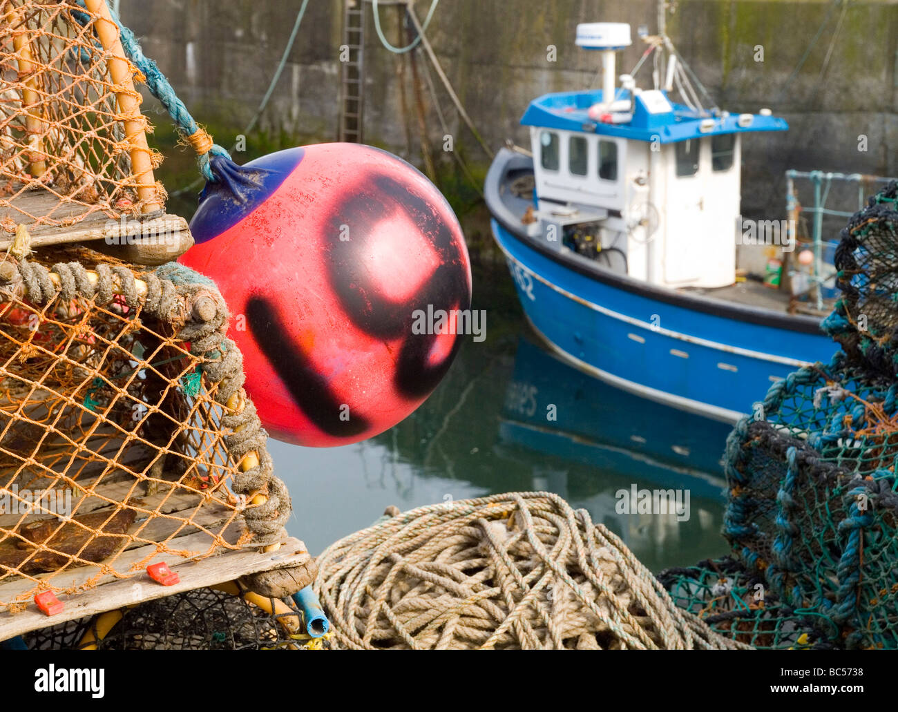 A boat and fishing crates in the harbour of St Abbs, a pretty fishing ...