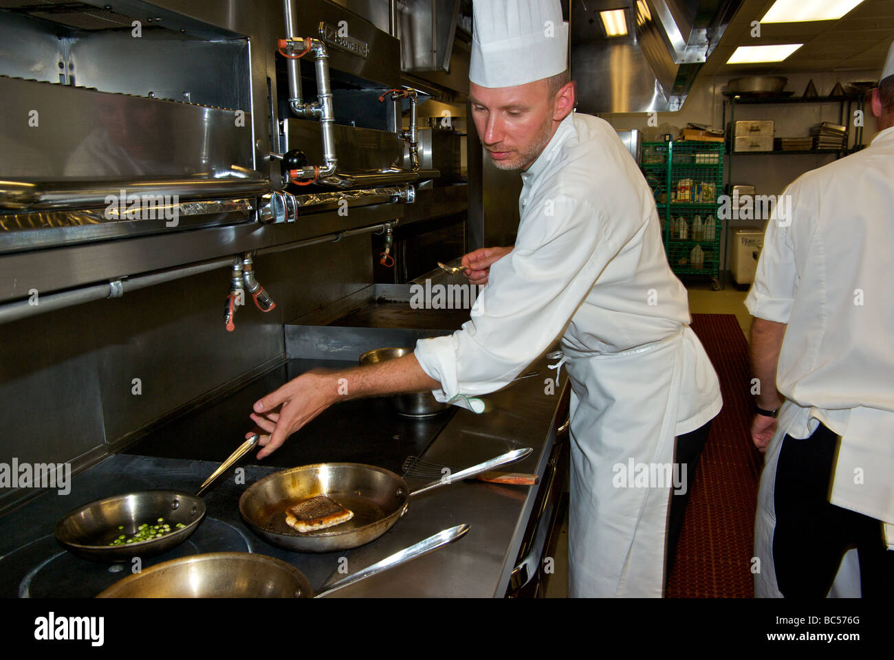 Chef Daniel Buss checking that sauteed legumes and boneless snapper ...